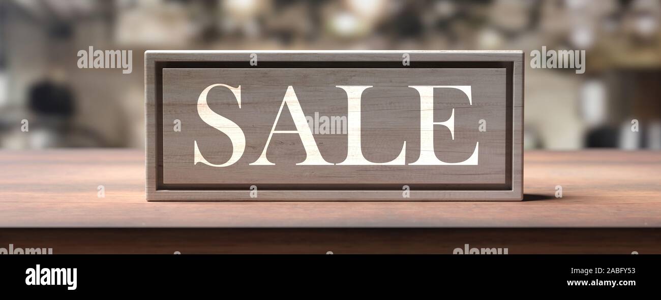 Sale concept. SALE text on a wood block sign on a wooden table, blur ...
