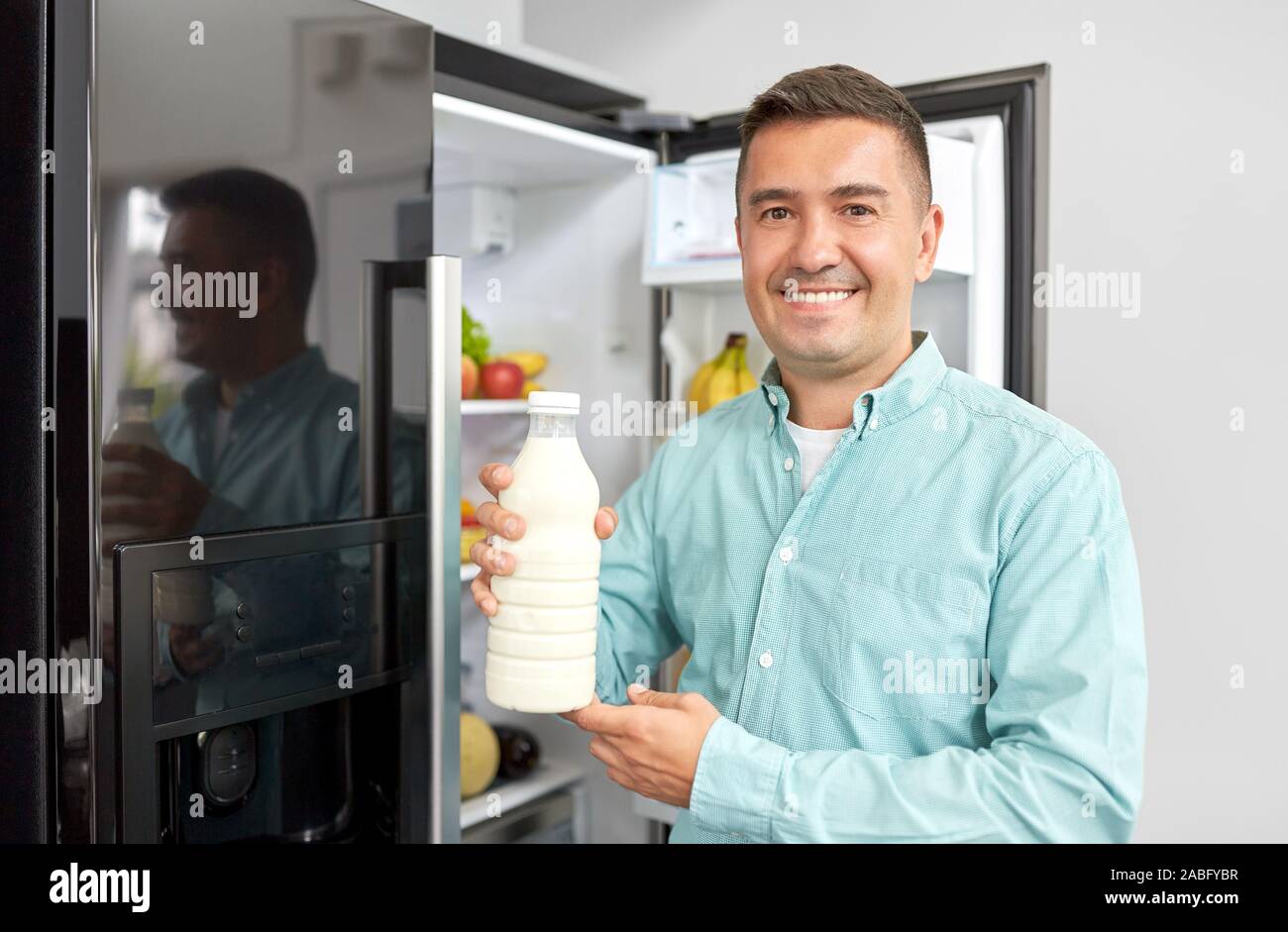 man taking milk from fridge at home kitchen Stock Photo - Alamy