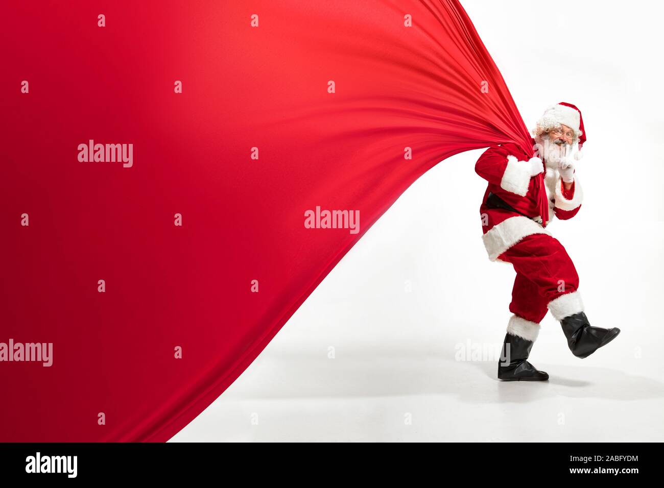 Santa Claus pulling huge bag full of christmas presents isolated on ...