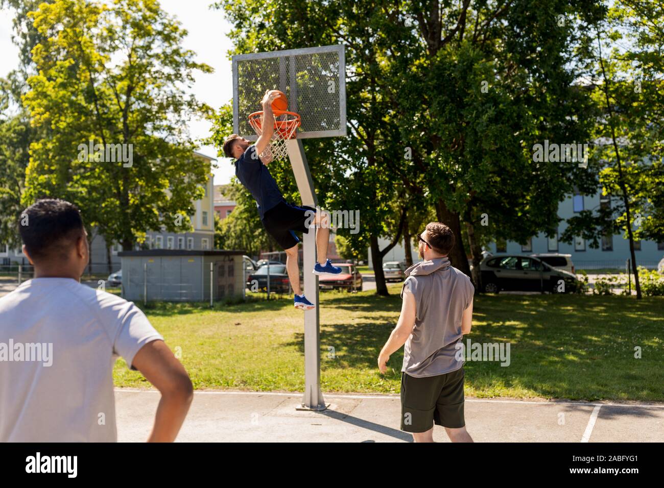 group of male friends playing street basketball Stock Photo - Alamy