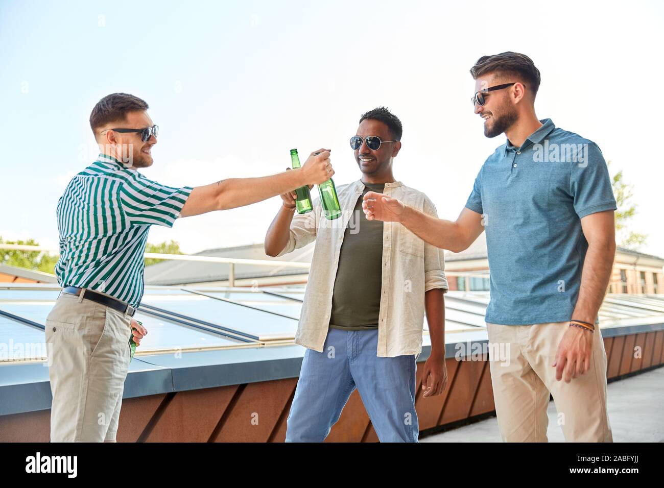 happy male friends drinking beer at rooftop party Stock Photo - Alamy