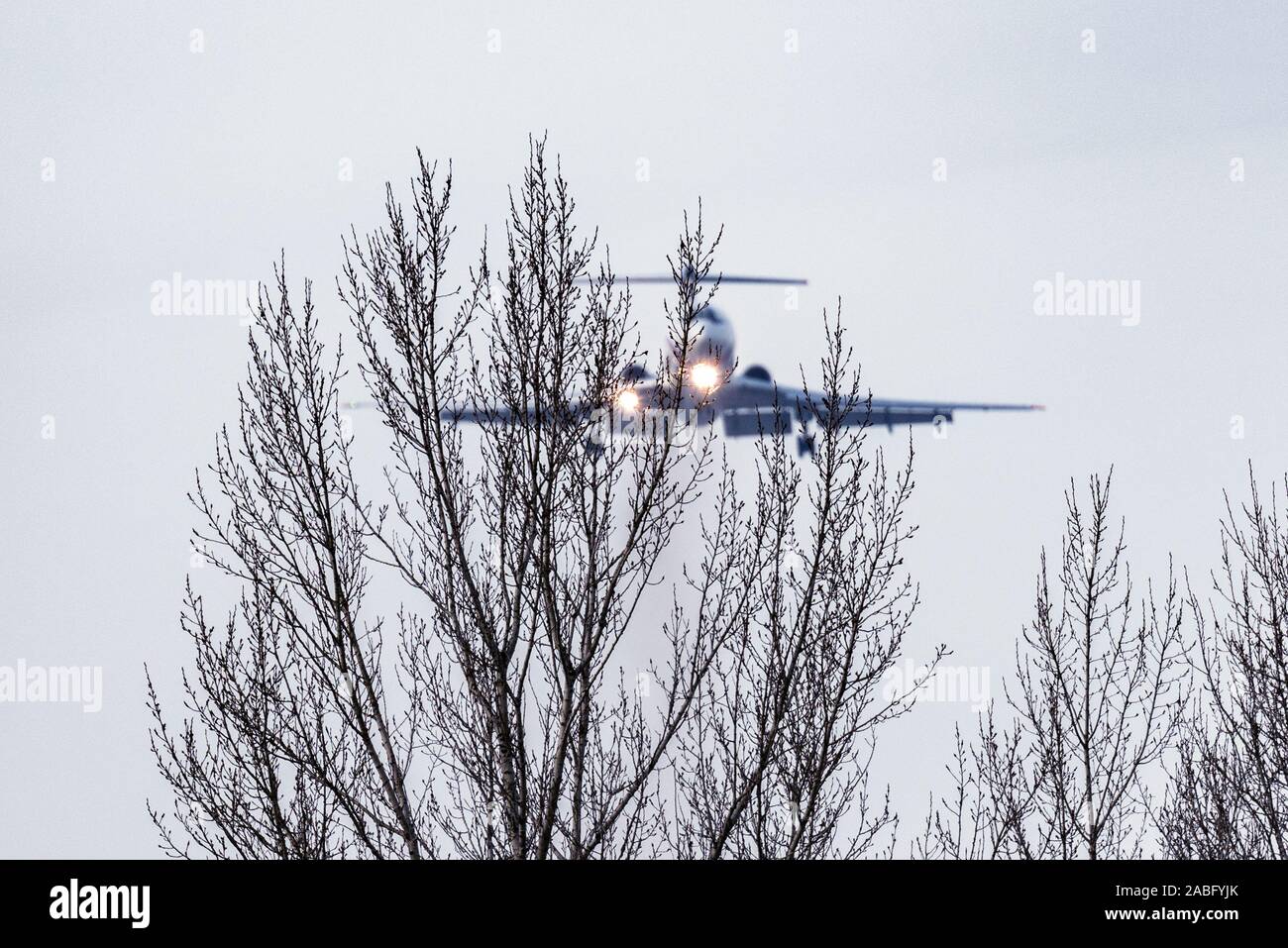 Passenger plane in the clear sky at evening time on the autumn trees ...