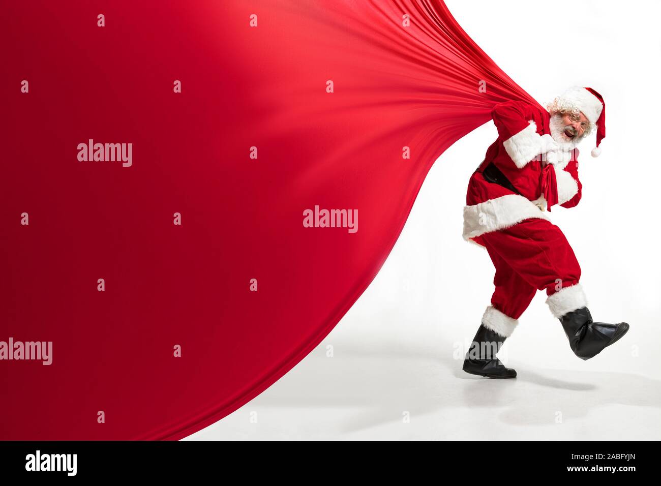 Santa Claus pulling huge bag full of christmas presents isolated on ...