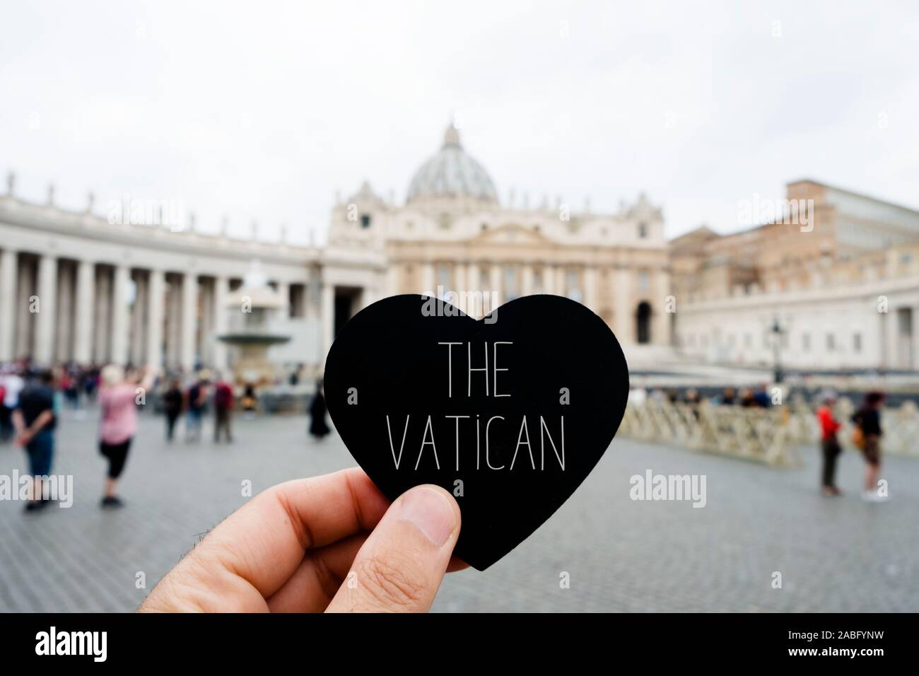 closeup of the hand of a caucasian man holding a black heart-shaped ...