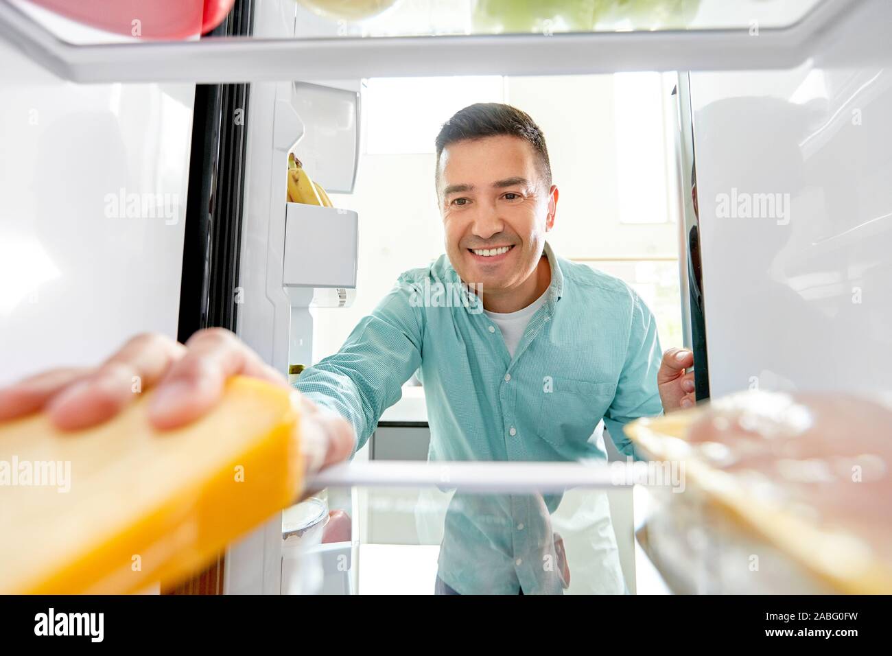 man taking food from fridge at kitchen Stock Photo - Alamy