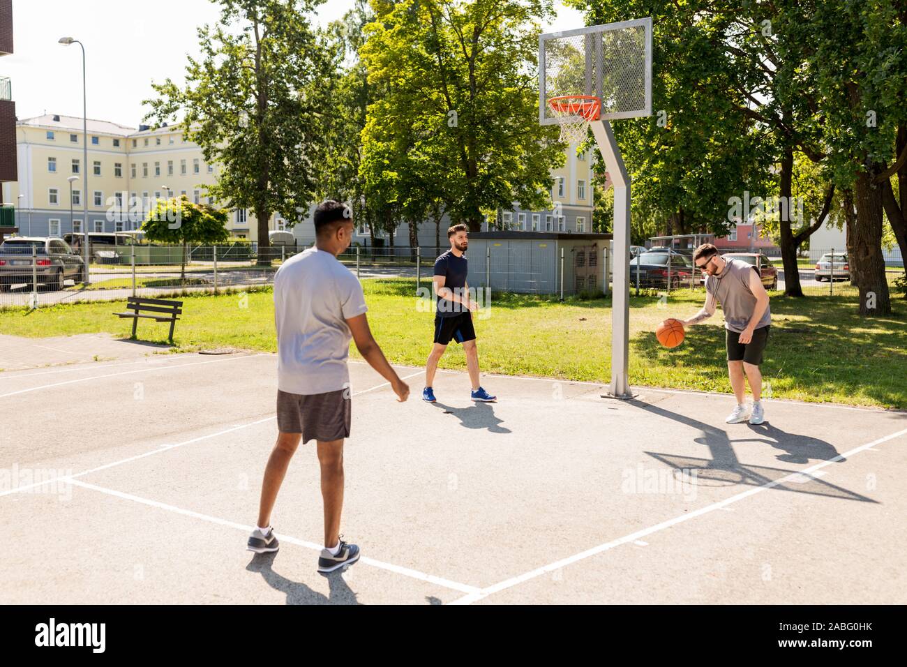 group of male friends playing street basketball Stock Photo - Alamy