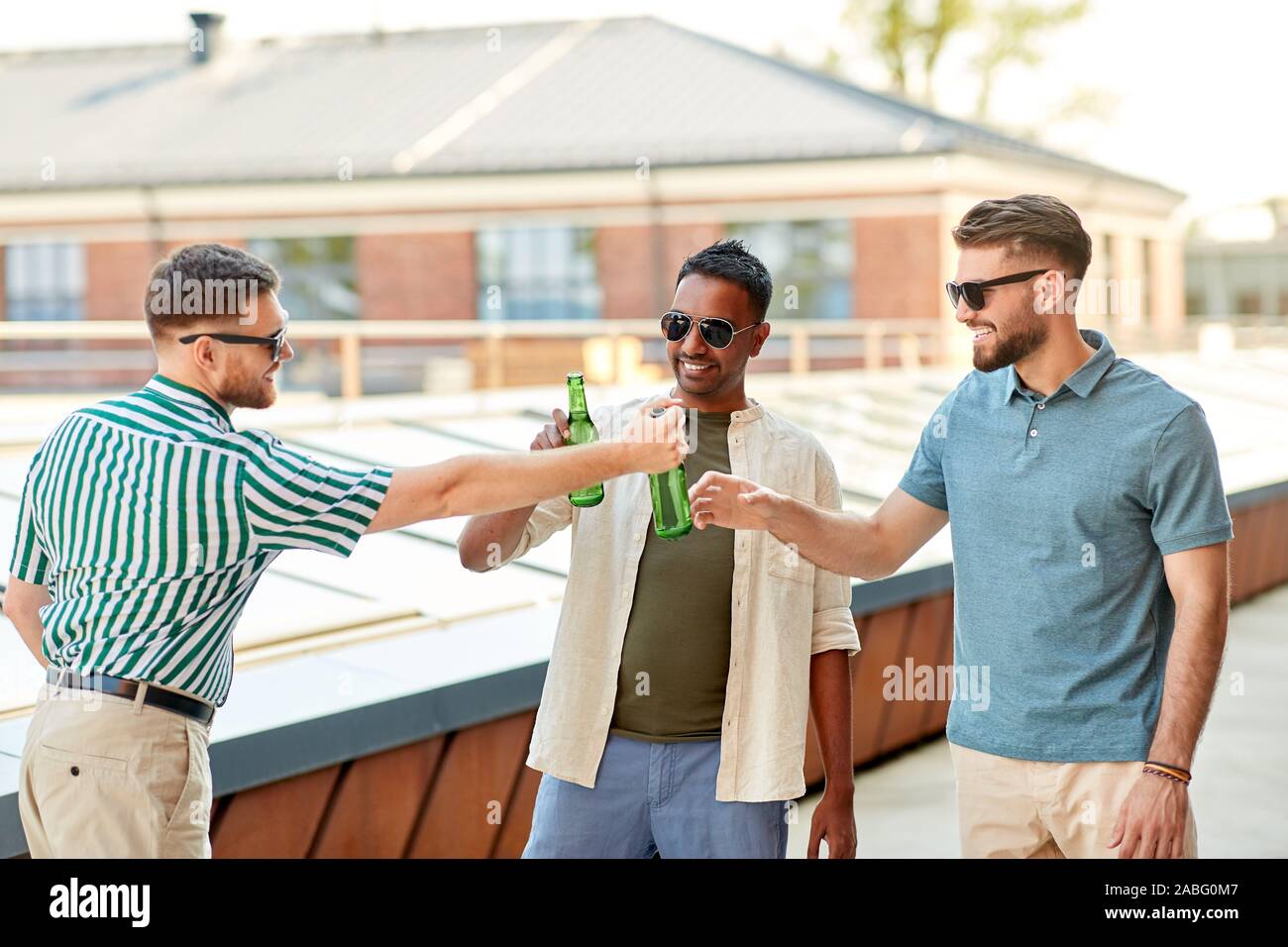 happy male friends drinking beer at rooftop party Stock Photo - Alamy