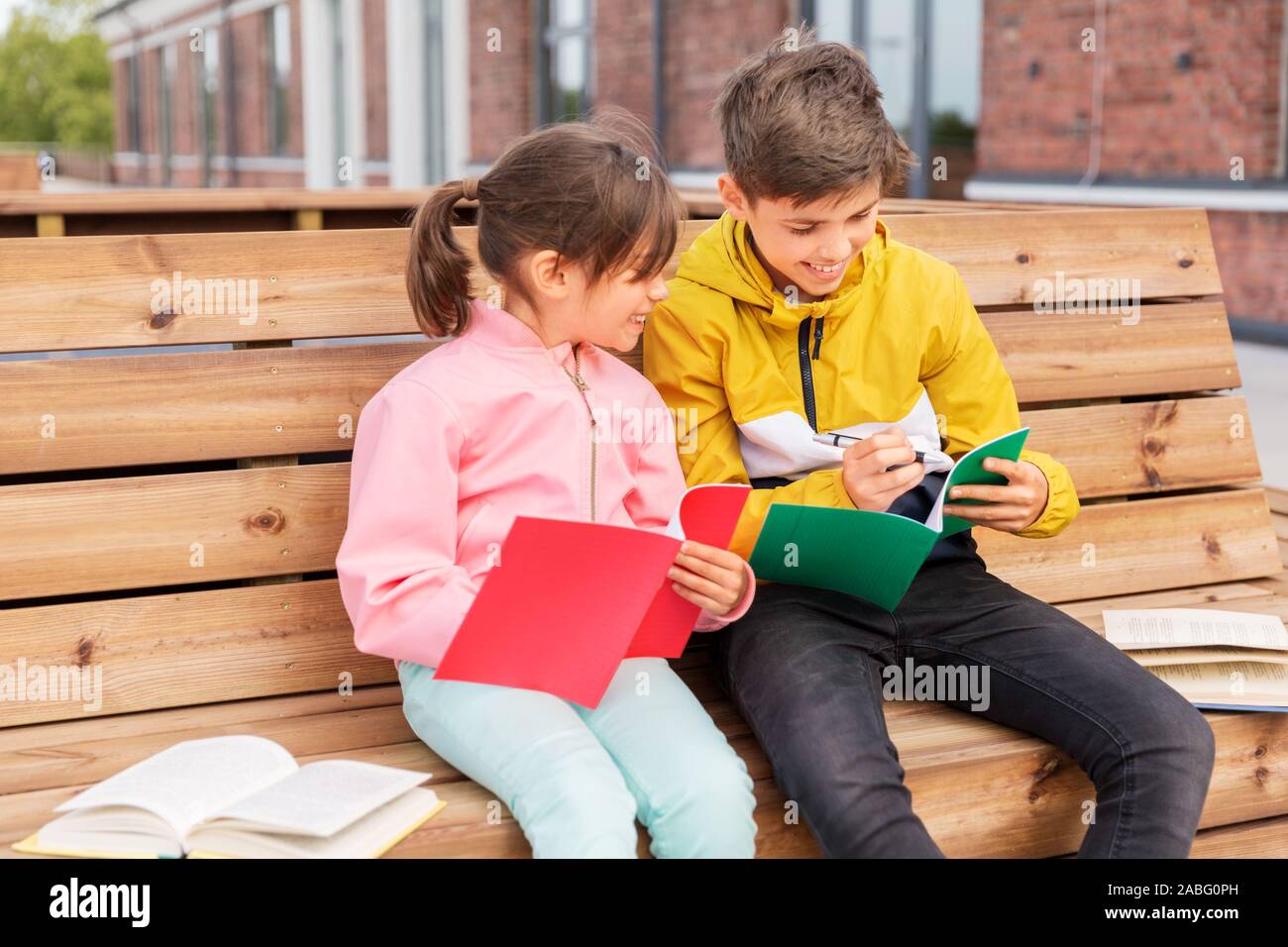 school children with notebooks sitting on bench Stock Photo - Alamy