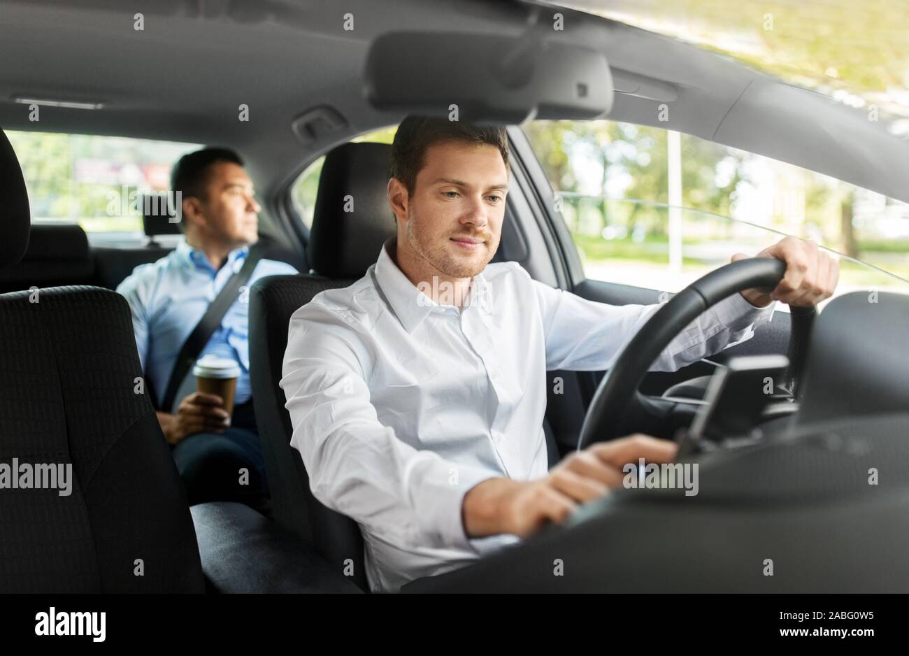 male driver driving car with passenger Stock Photo - Alamy