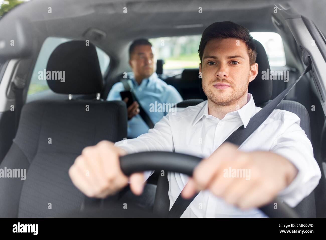 male driver driving car with passenger Stock Photo - Alamy