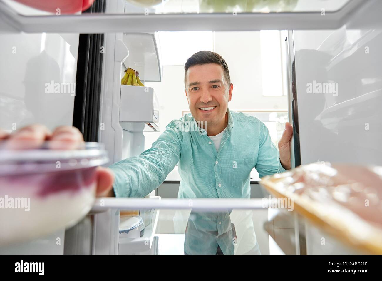 man taking food from fridge at kitchen Stock Photo - Alamy