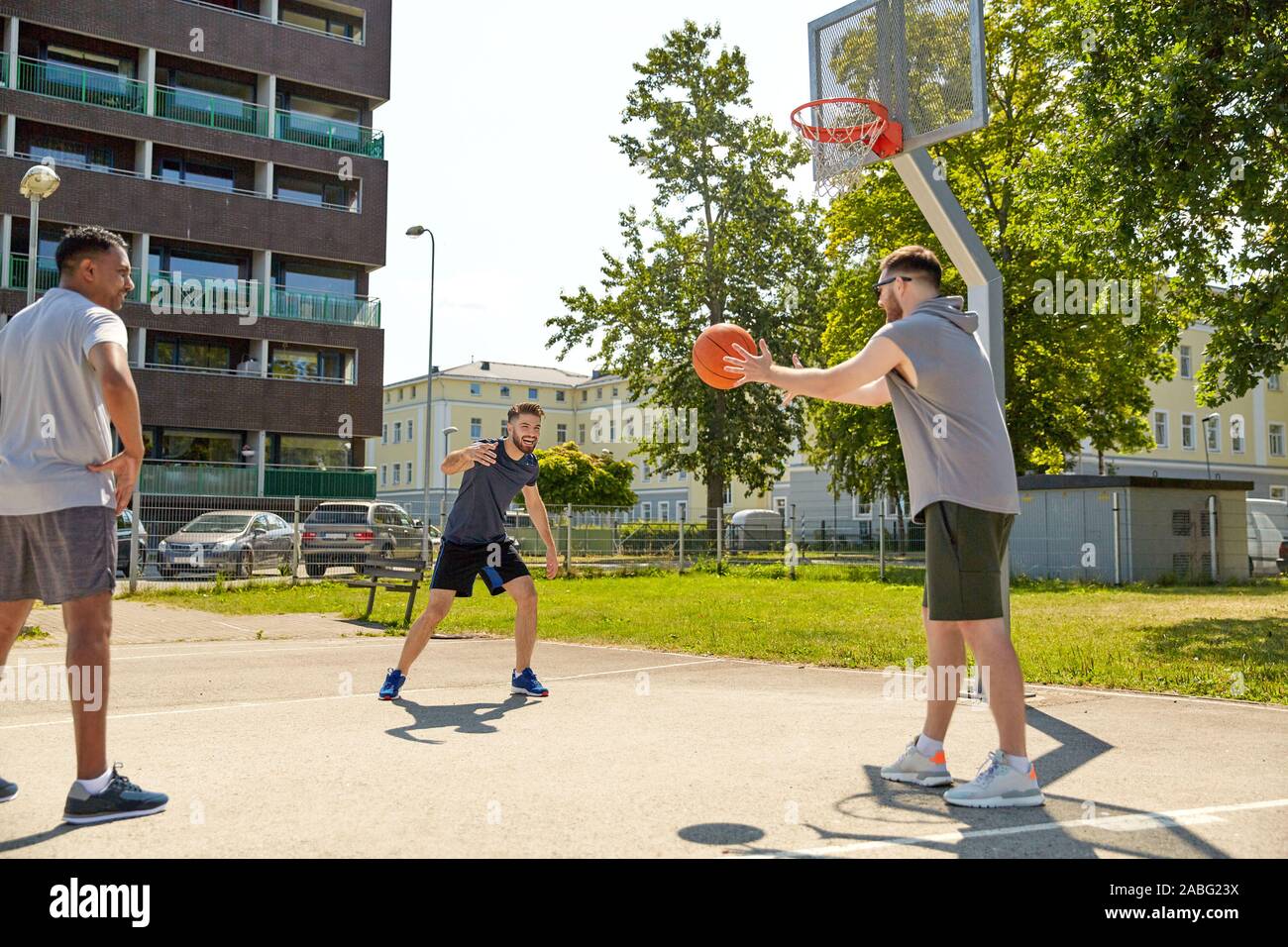 group of male friends playing street basketball Stock Photo - Alamy