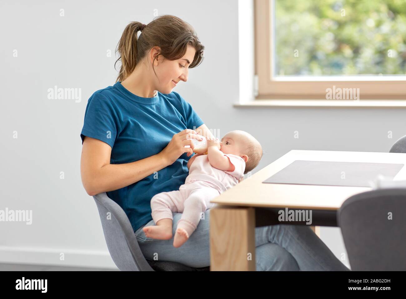 mother feeding baby daughter with milk formula Stock Photo - Alamy