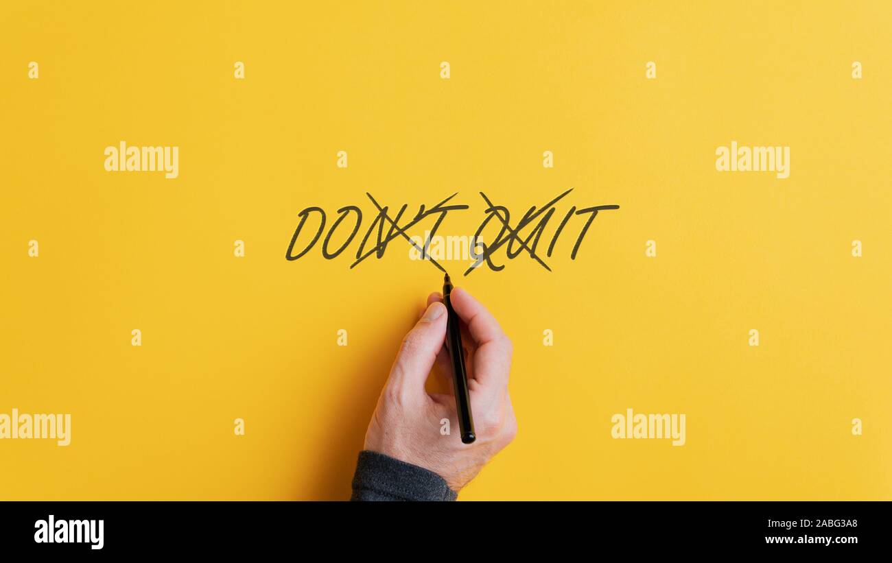 Male hand crossing off a Don't quit sign to change it into a Do it ...