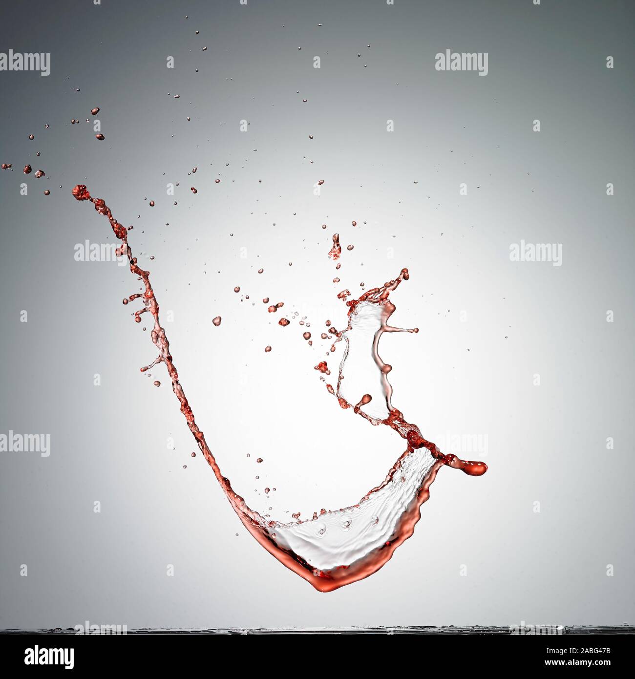 Red water splash shape on grey vignette background Stock Photo - Alamy