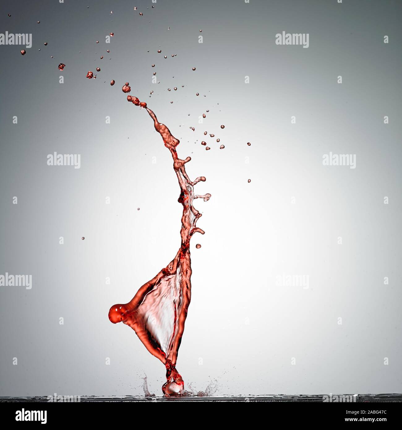 Red water splash shape on grey vignette background Stock Photo - Alamy