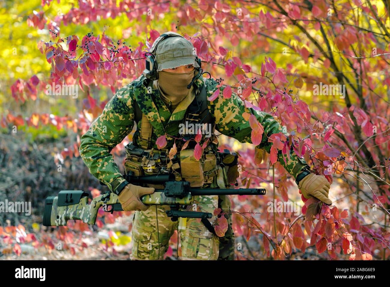 Airsoft man in uniform with machine gun and night-vision device on ...