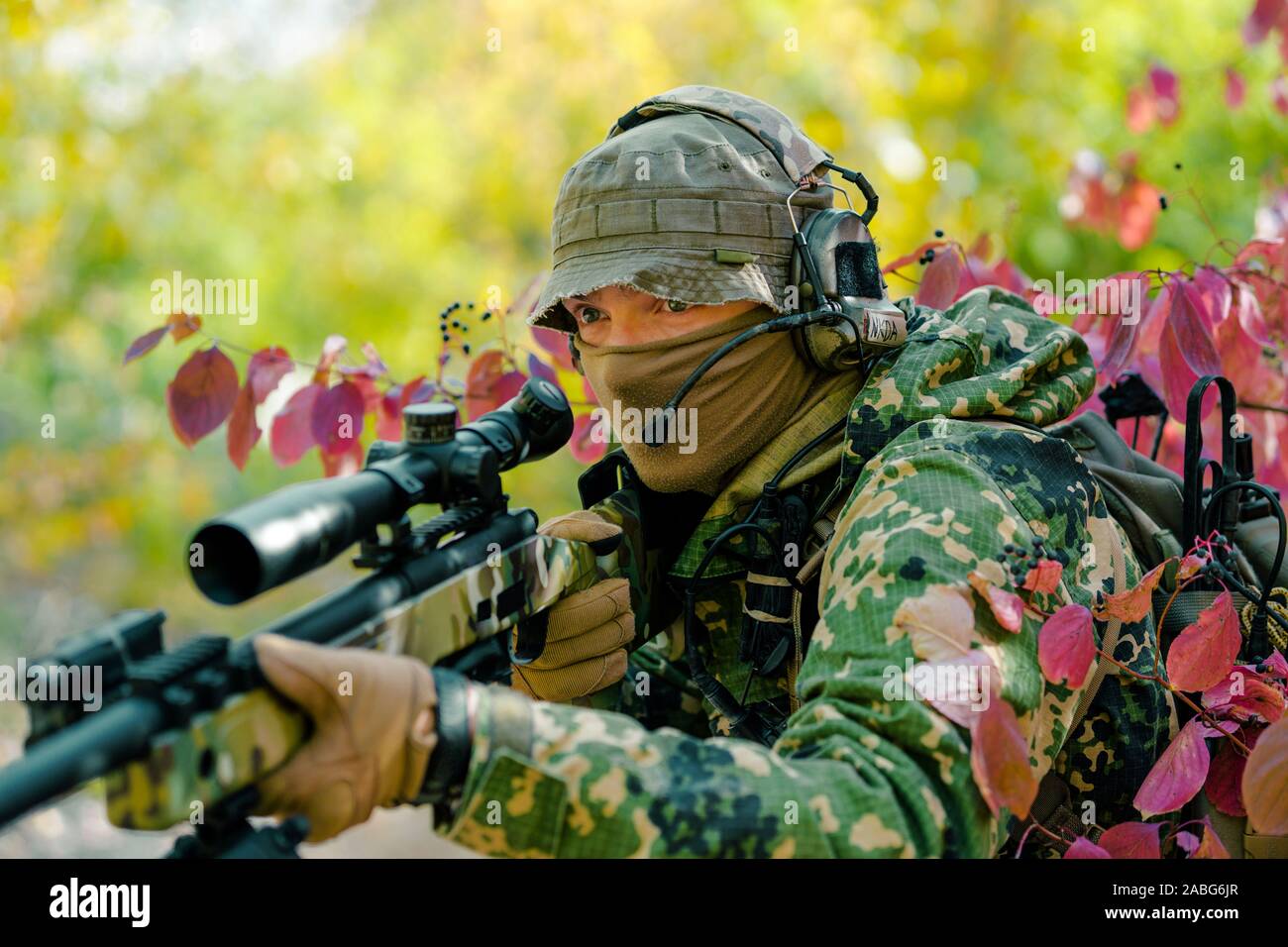 Airsoft man in uniform with machine gun and night-vision device on ...
