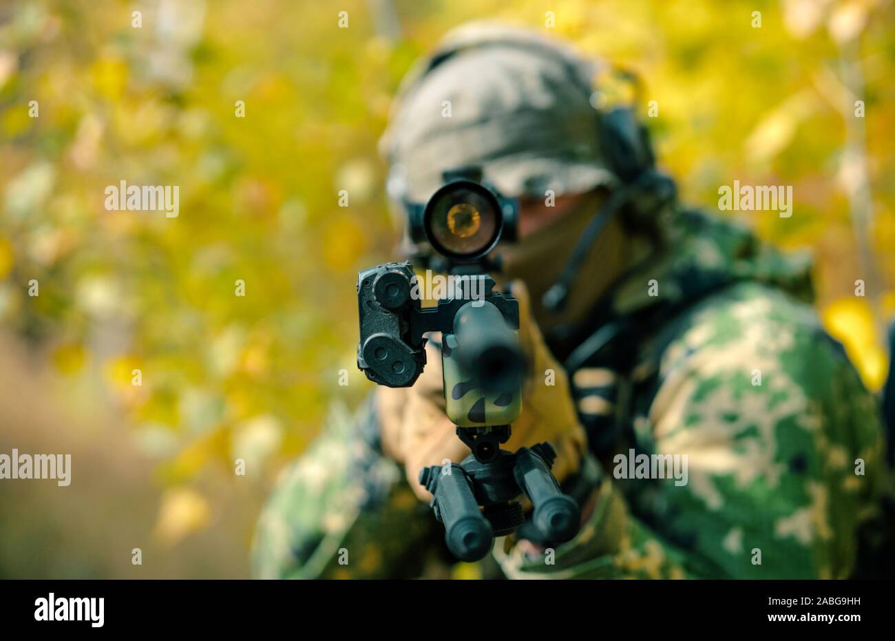Closeup airsoft man in uniform, stand with sniper rifle on yellow ...