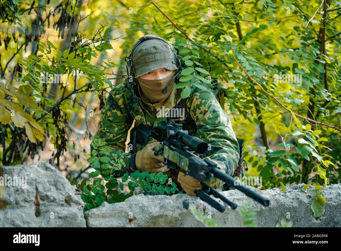 Airsoft man in uniform with machine gun and night-vision device on ...