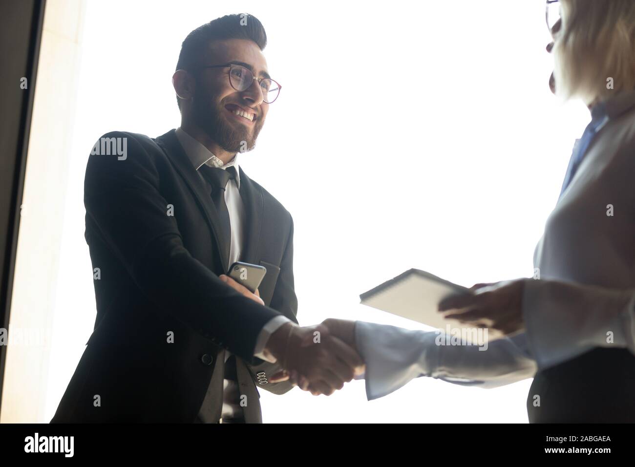 Smiling Arabian businessman handshake female colleague Stock Photo - Alamy