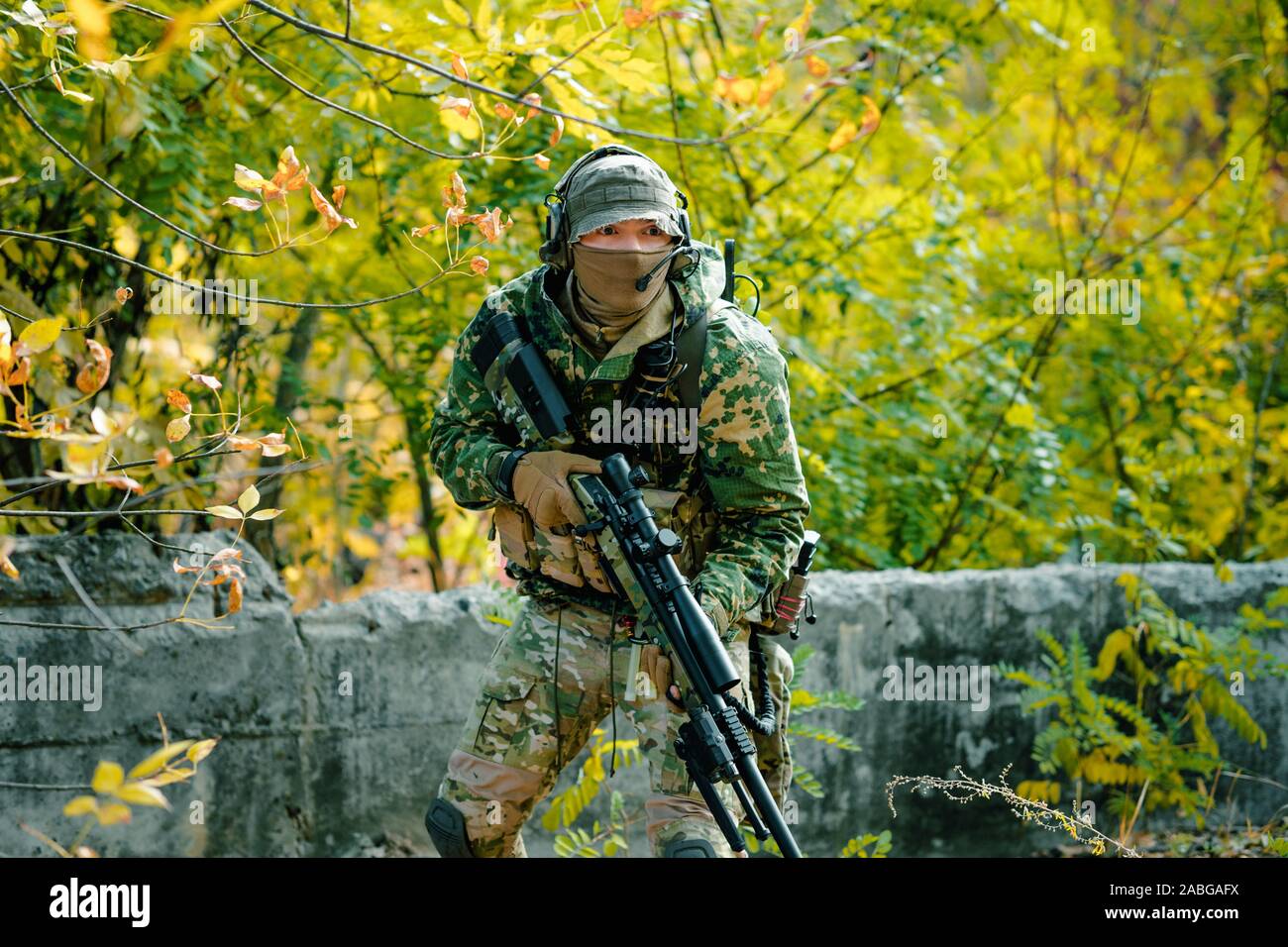 Airsoft man in uniform with machine gun and night-vision device on ...