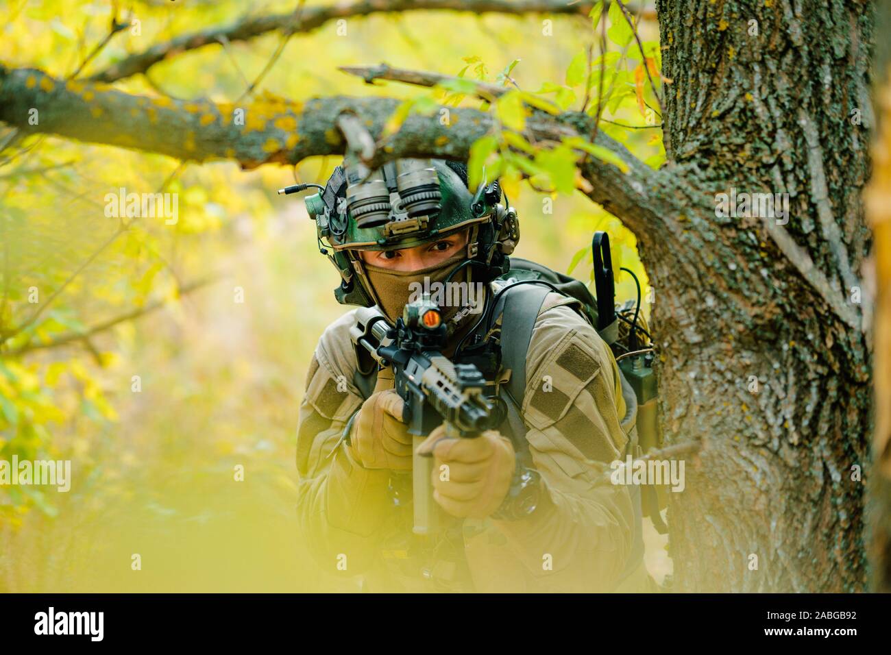 Airsoft man in uniform with machine gun and night-vision device on ...