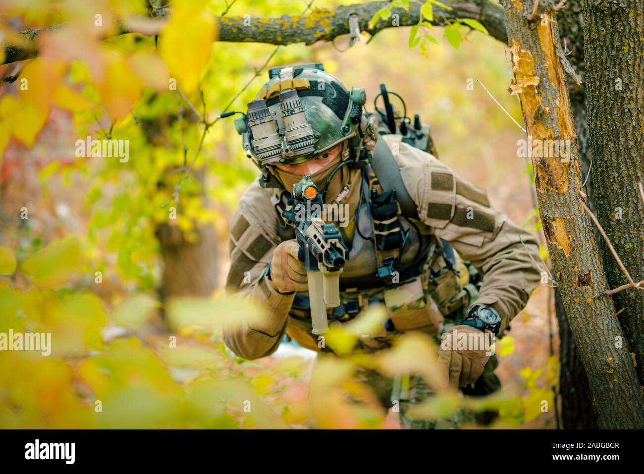 Airsoft man in uniform with machine gun and night-vision device on ...