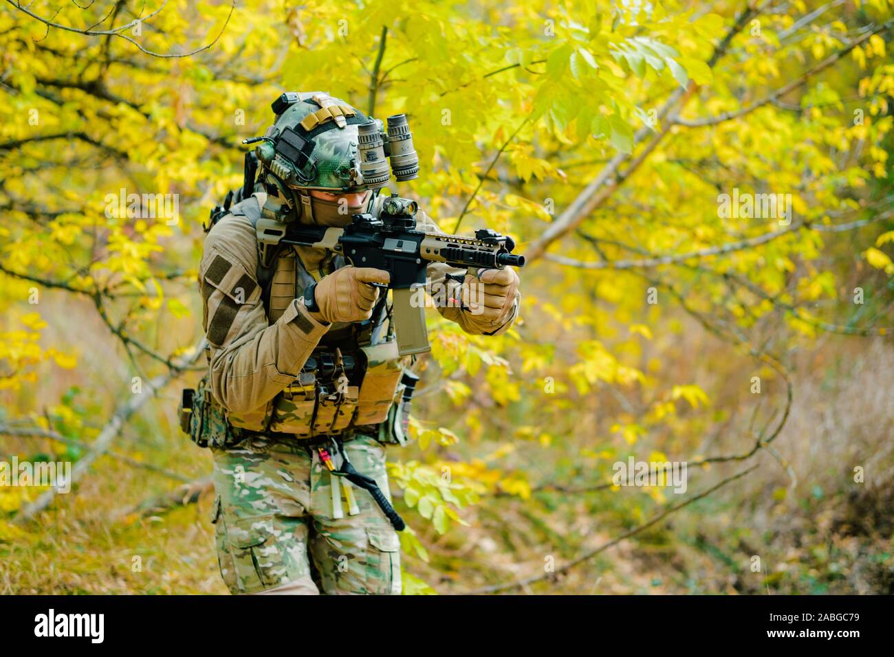 Airsoft man in uniform with machine gun and night-vision device on ...