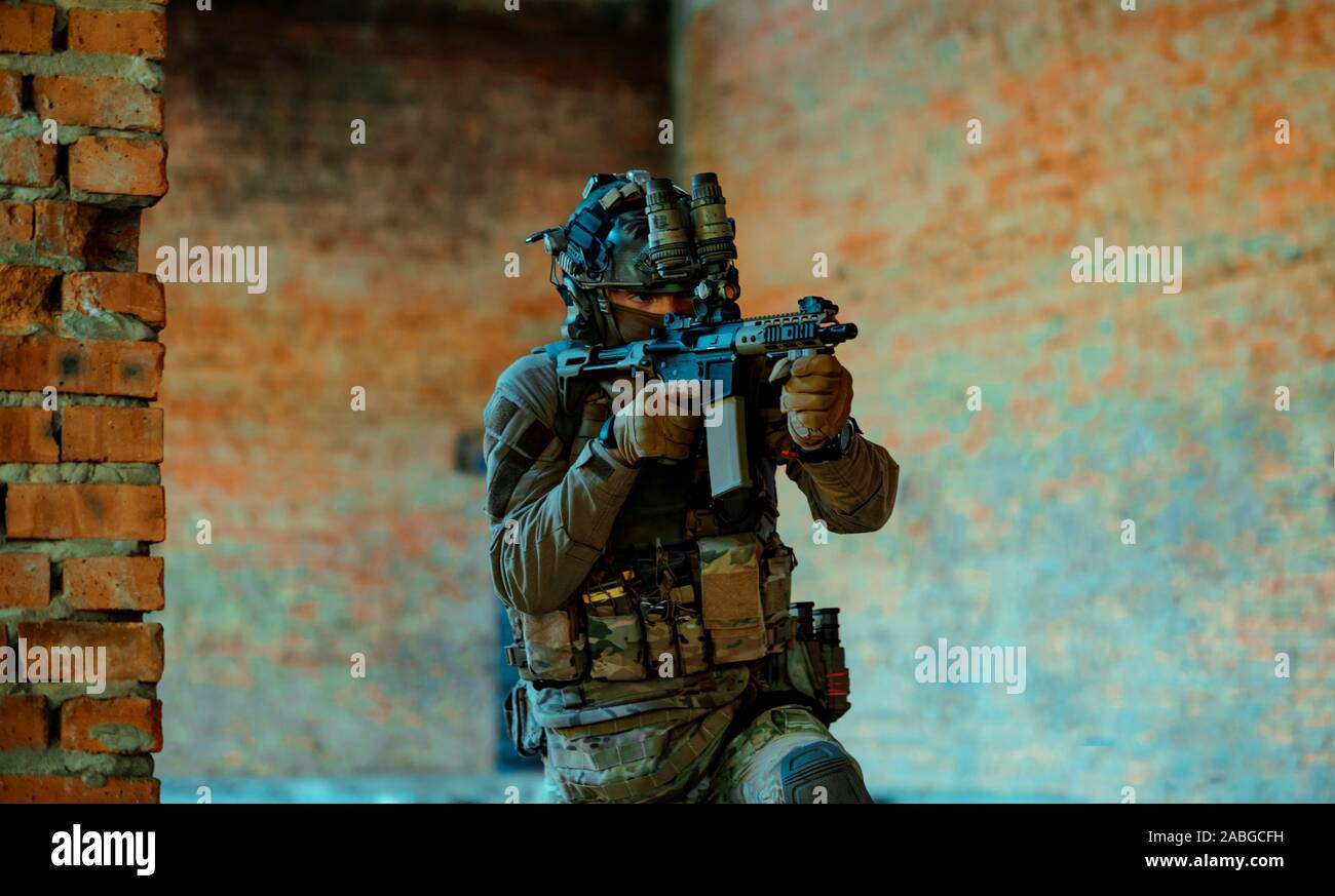 Airsoft man in uniform with machine gun and night-vision device on ...