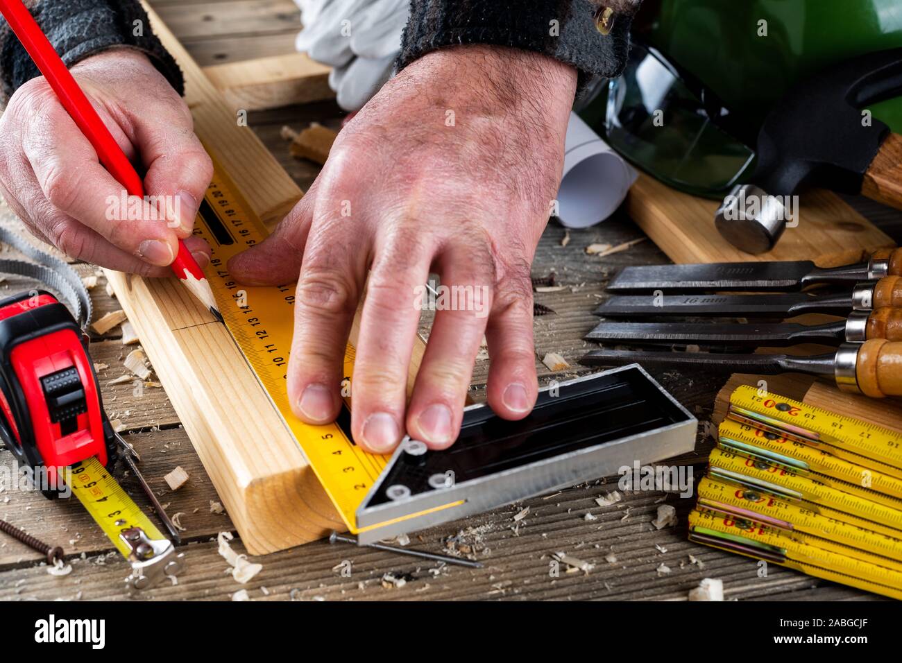 Top view. Carpenter with pencil and the carpenter's square draw the ...