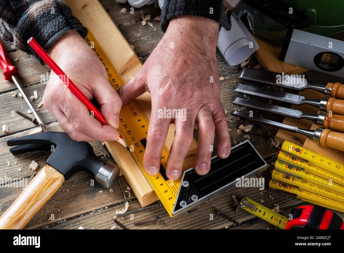 Top view. Carpenter with pencil and the carpenter's square draw the ...