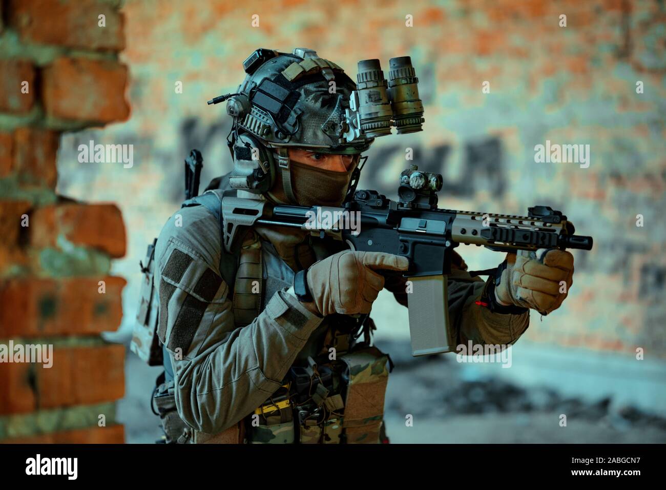Airsoft man in uniform with machine gun and night-vision device on ...