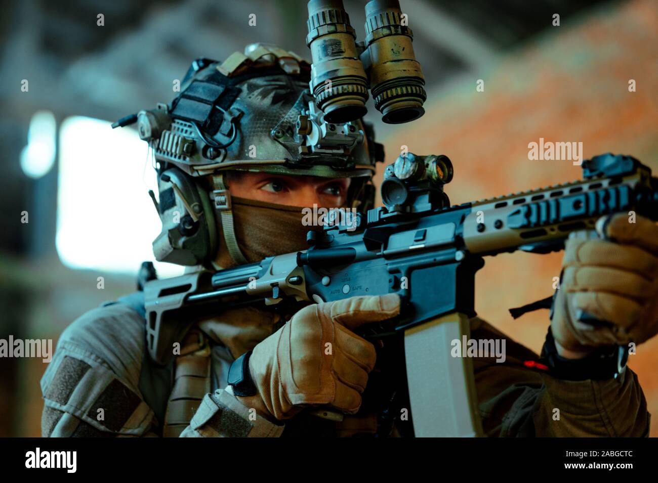 Airsoft man in uniform with machine gun and night-vision device on ...