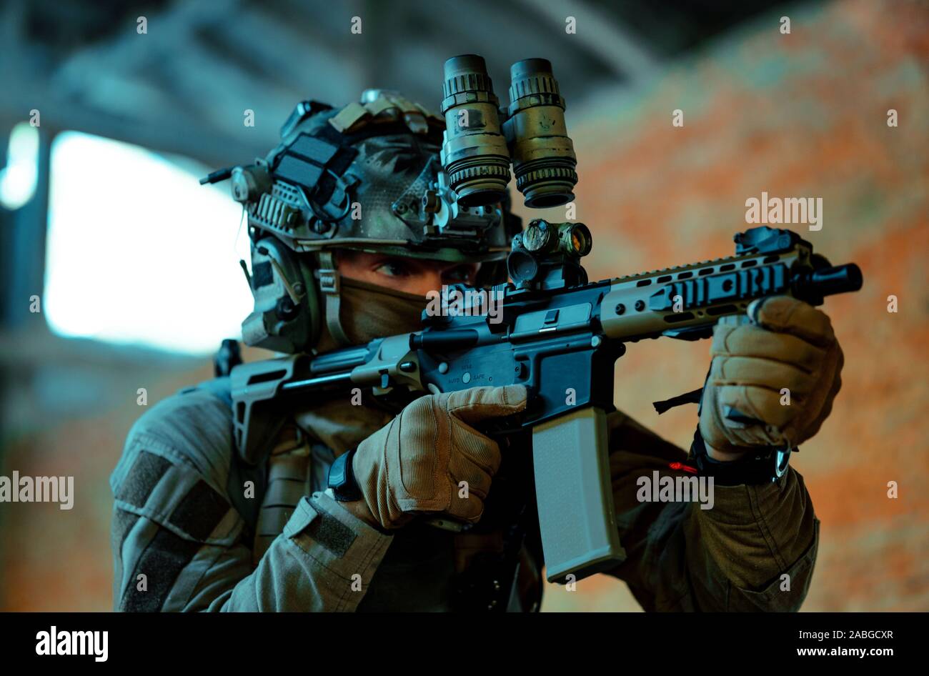 Airsoft man in uniform with machine gun and night-vision device on ...