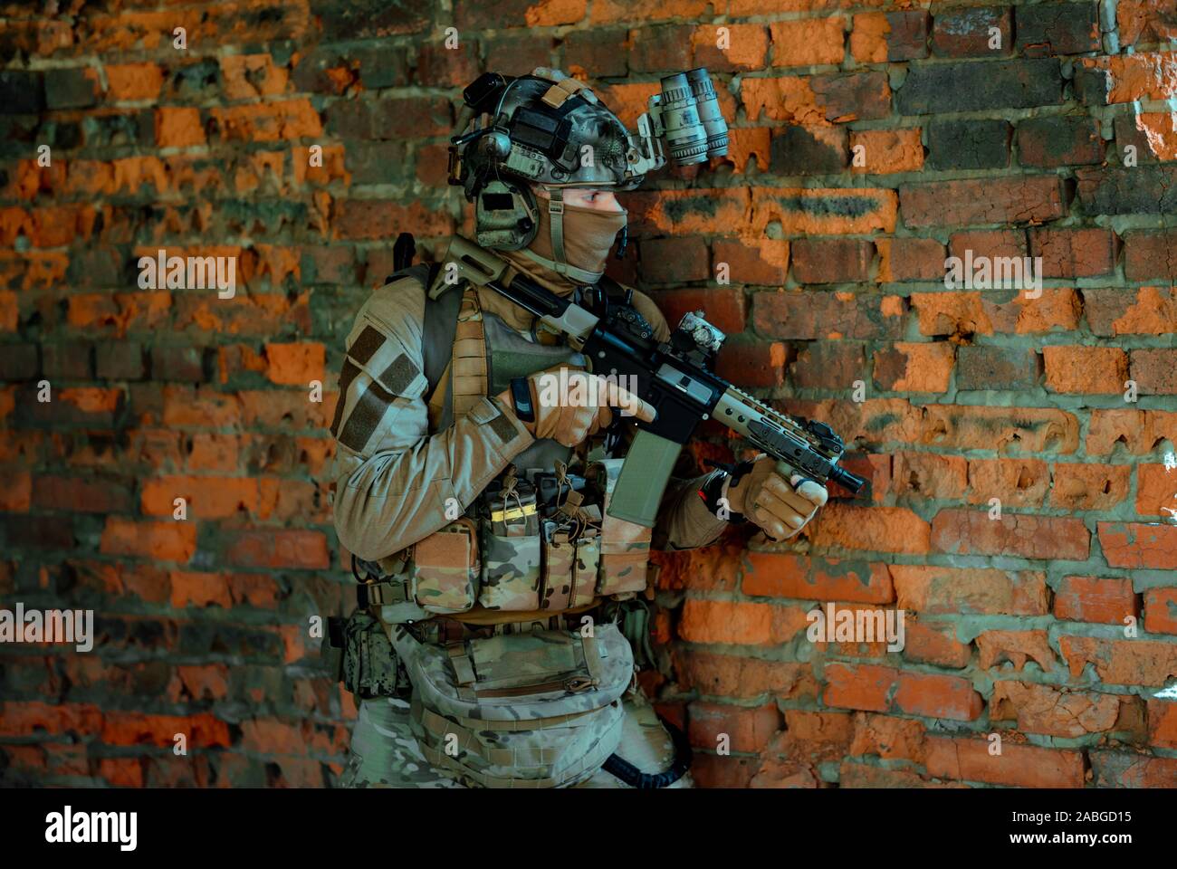 Airsoft man in uniform with machine gun and night-vision device on ...