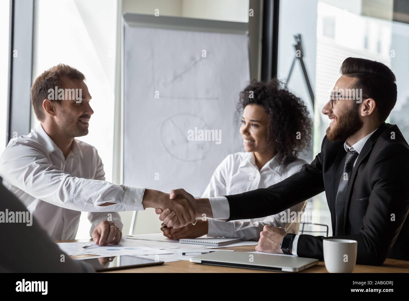 Smiling businessmen handshake closing deal at meeting Stock Photo - Alamy