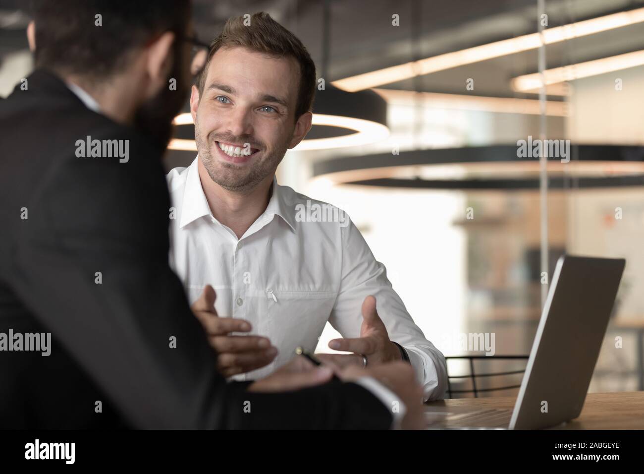 Smiling Caucasian businessman talk cooperating with male colleague ...