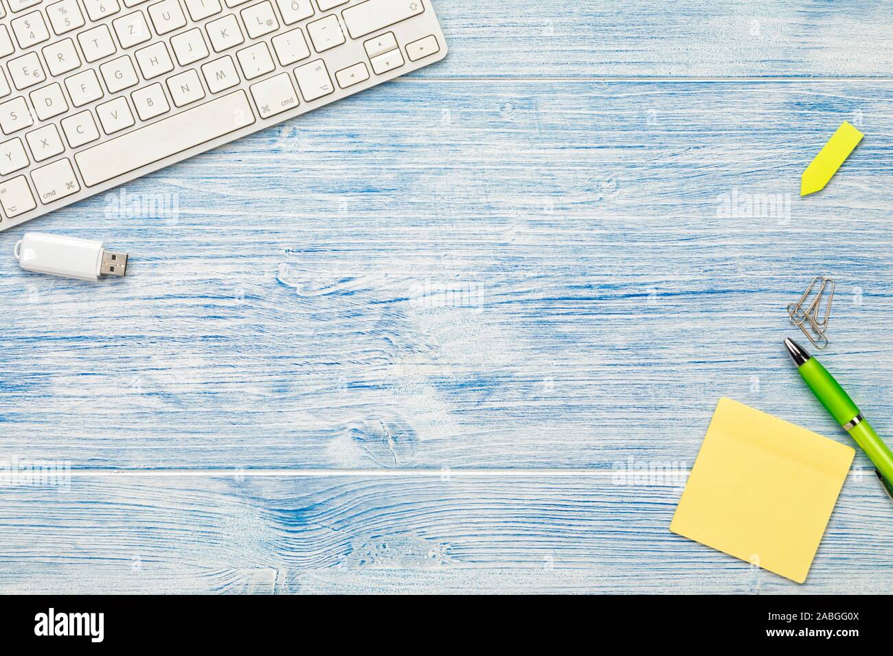 Desktop with computer keyboard, USB stick, blank sticky paper and ...