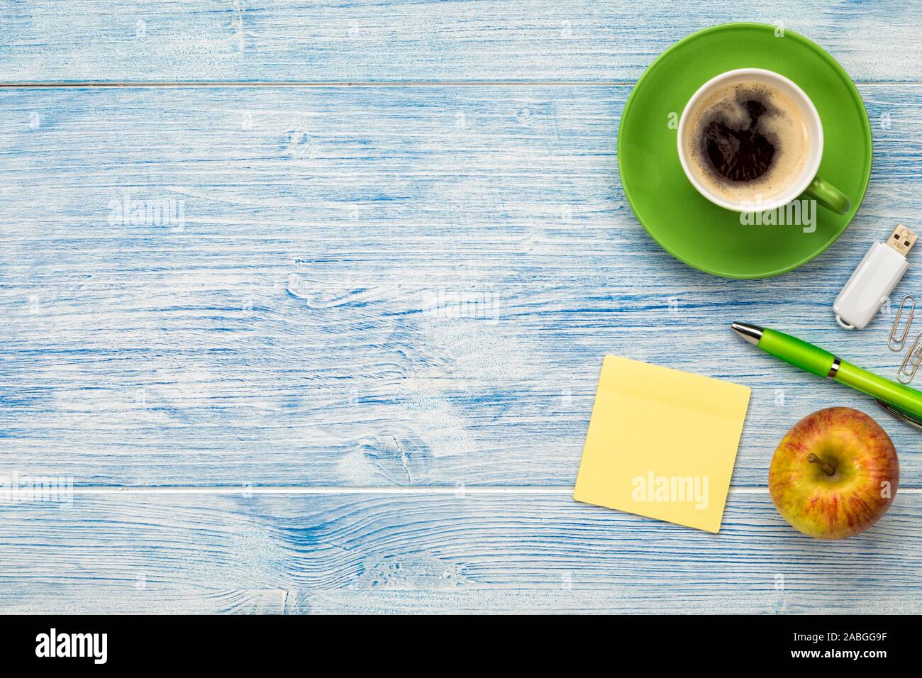 Desktop with coffee cup, apple, sticky paper and utensils flat lay ...