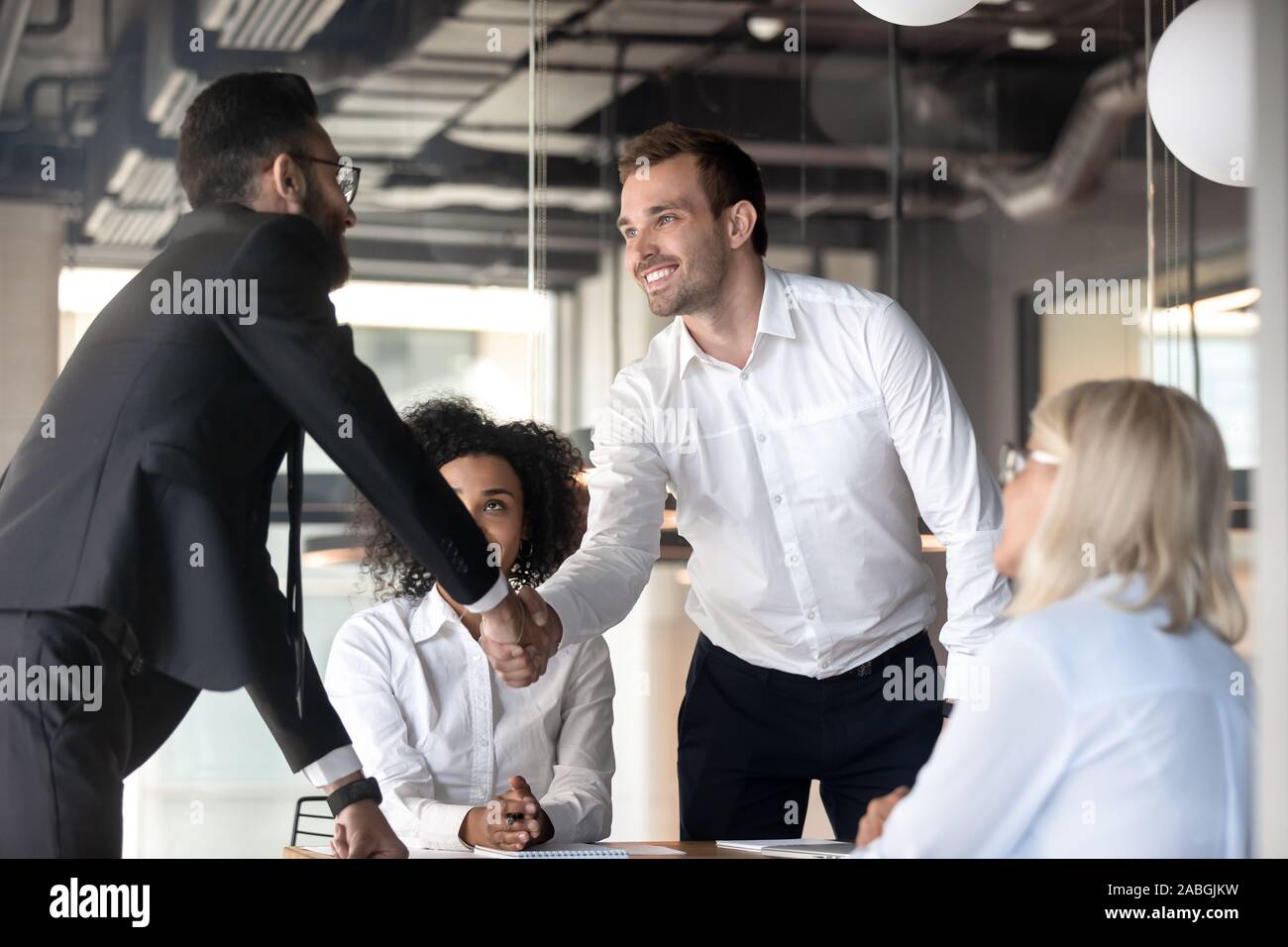 Smiling male partners handshake greeting at business meeting Stock ...