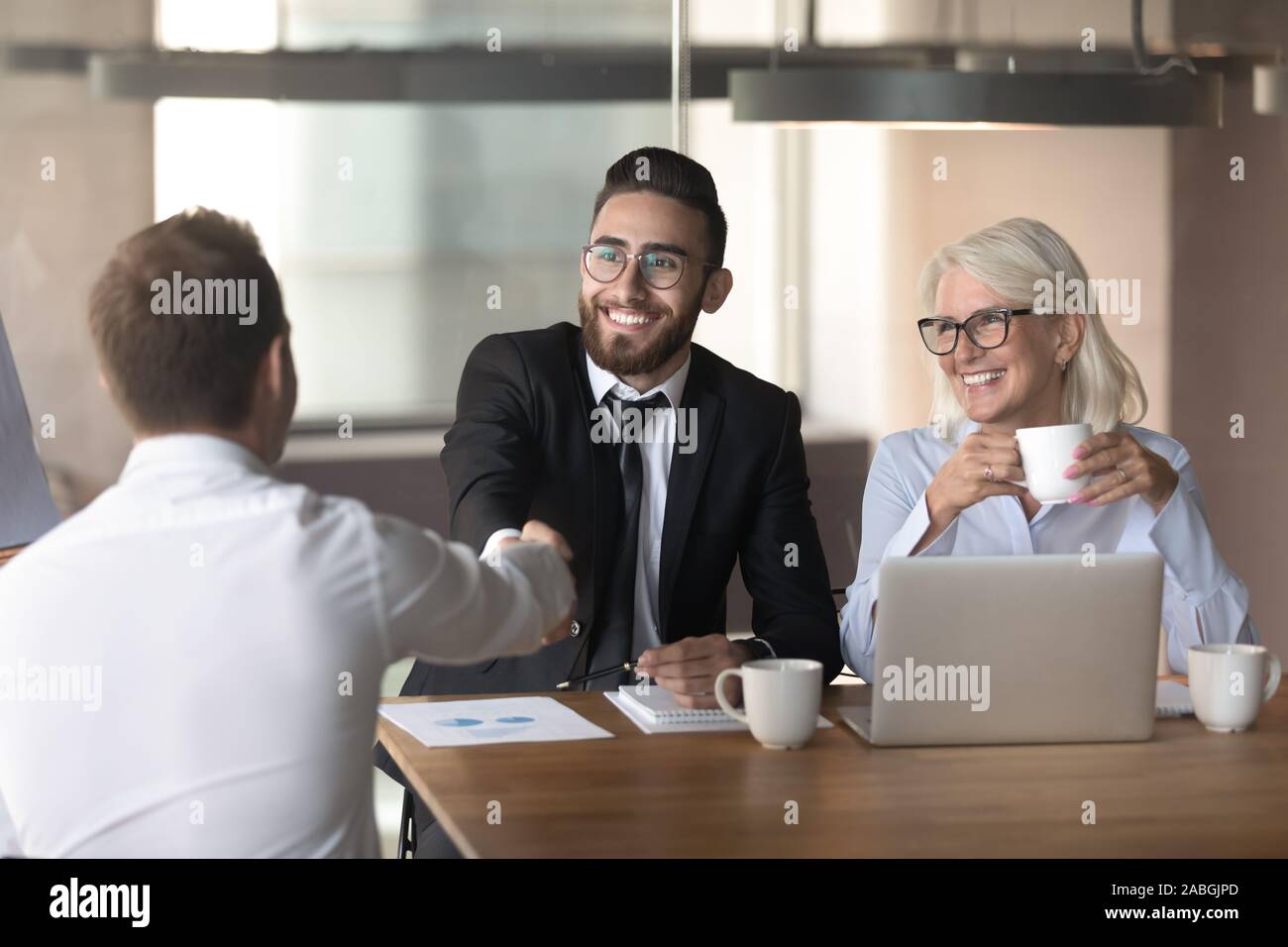 Smiling diverse employers handshake job applicant at interview Stock ...