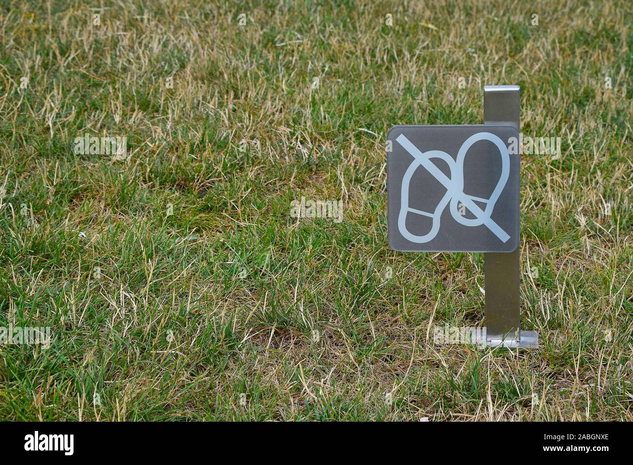 Close up keep off the grass warning sign over green lawn background ...