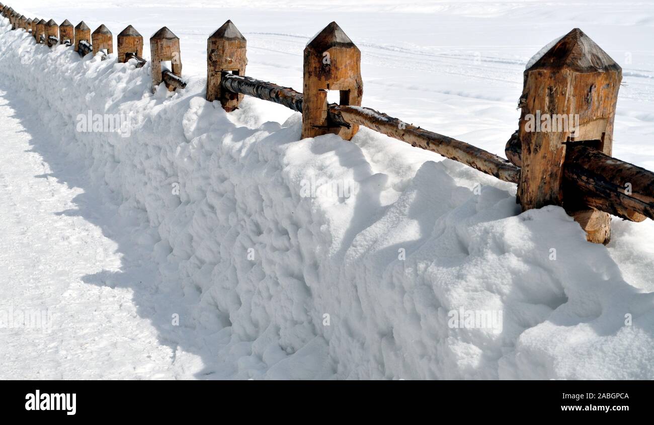 Wood in the snow frames the path Stock Photo - Alamy