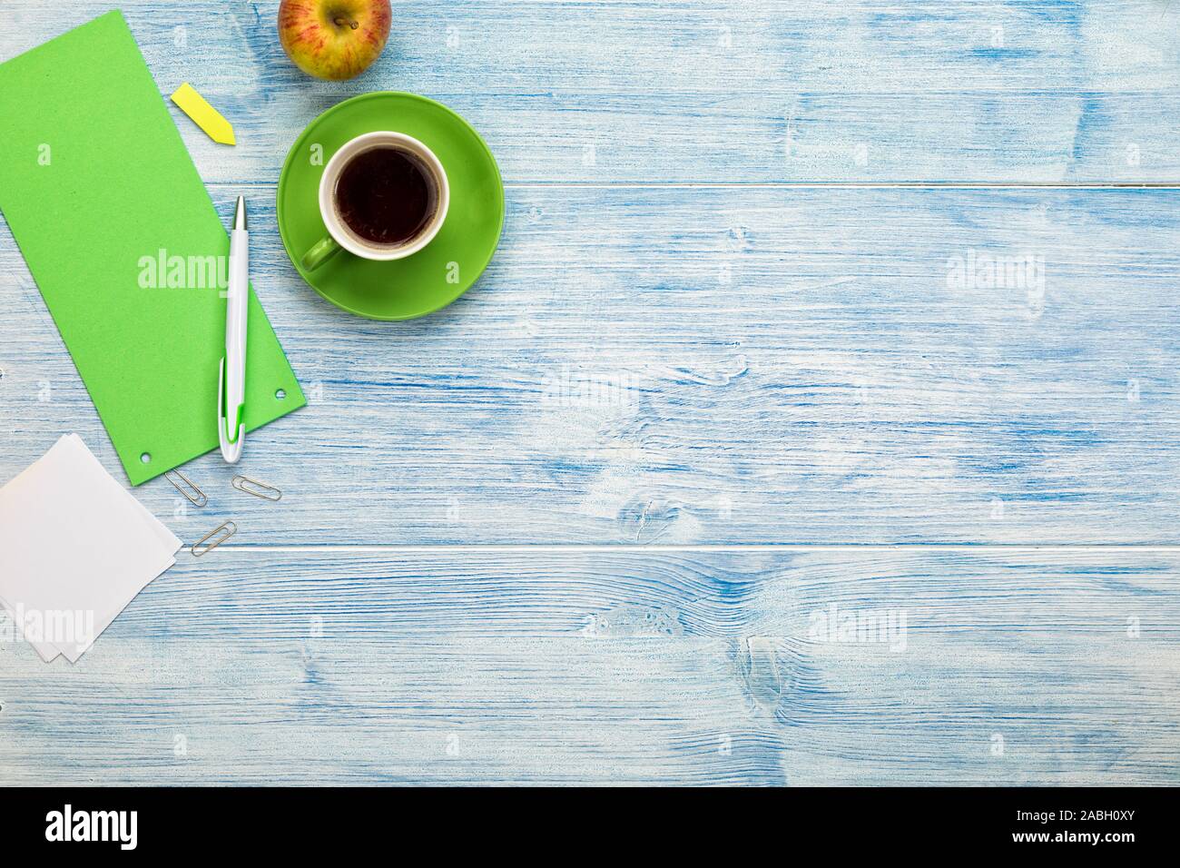 Desktop with coffee cup, apple, blank paper and utensils flat lay ...