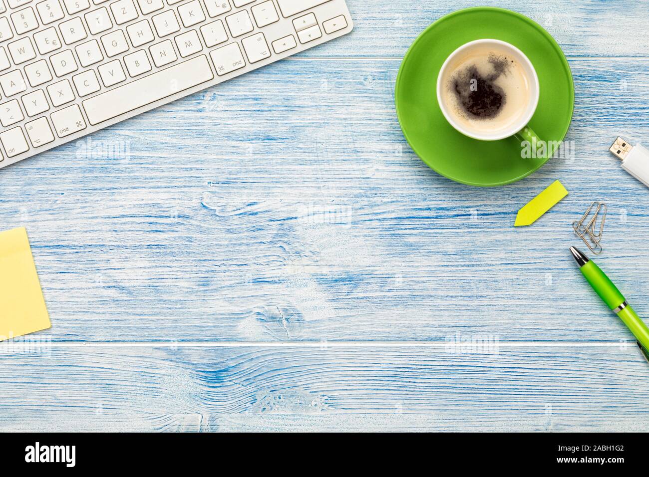 Desktop with coffee cup, computer keyboard and utensils flat lay ...