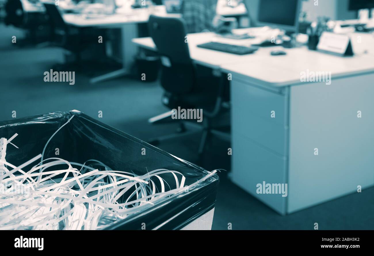 Shredded paper in a bin with blurred open space modern office in ...