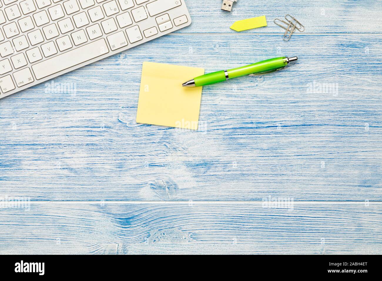 Desktop with computer keyboard, blank sticky paper and utensils flat ...