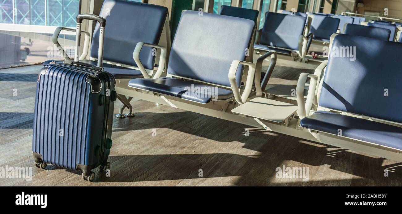 Small plastic travel suitcase in the airport hall Stock Photo - Alamy