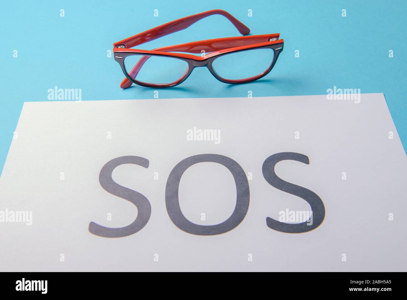 Word SOS written on white paper. Blue background Stock Photo - Alamy